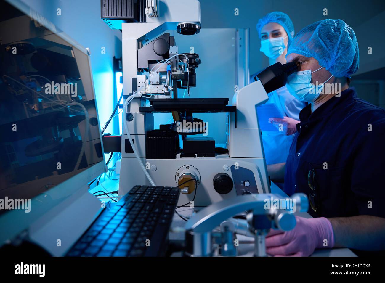 Two embryologists working with a micro-manipulation system Stock Photo ...