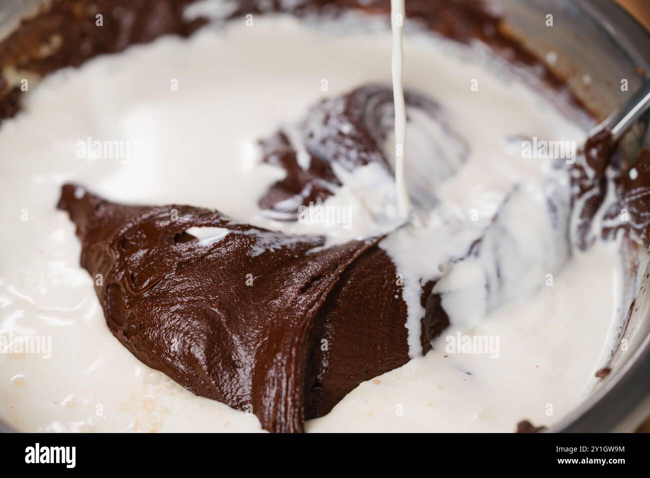 adding cream into melted chocolate, cooking process Stock Photo - Alamy