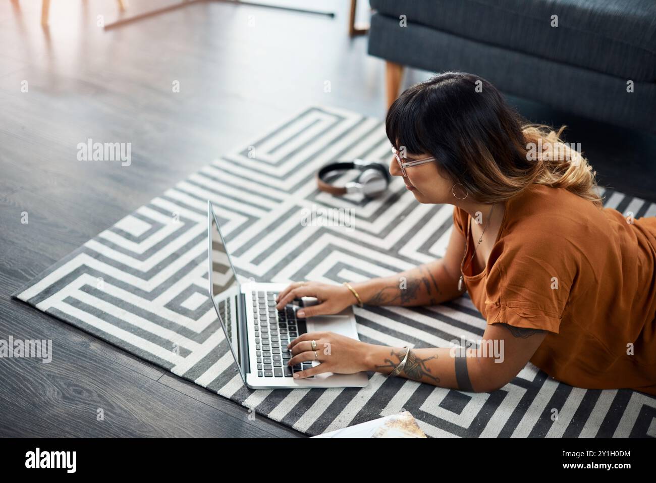 Typing, relax and woman with laptop, floor and ideas for composer ...