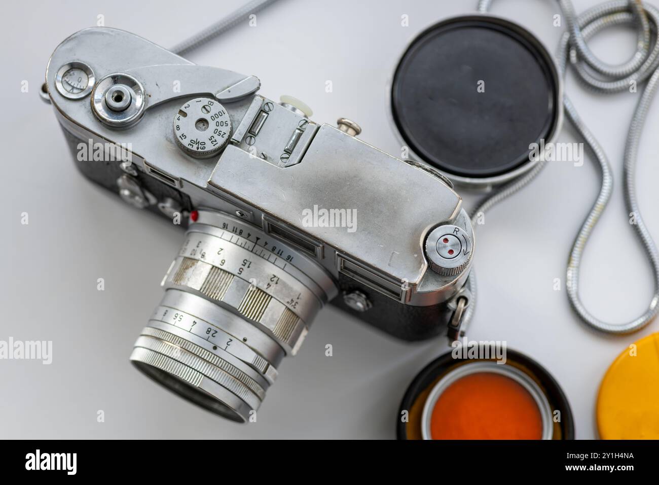 A classic vintage camera with lens cap and filter isolated in a white ...