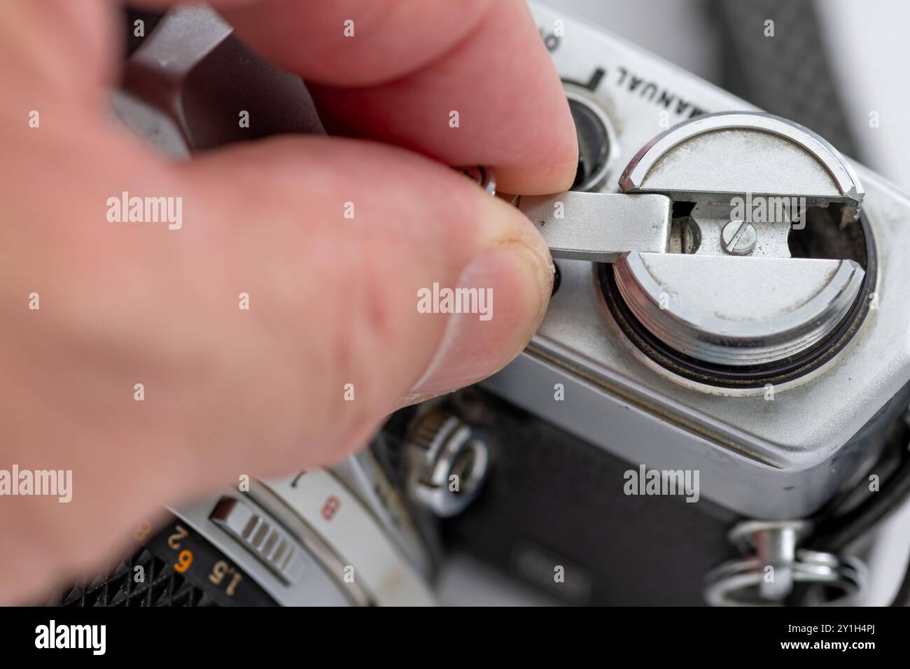 Close up of a person using the film roll rewind lever of a vintage SLR ...