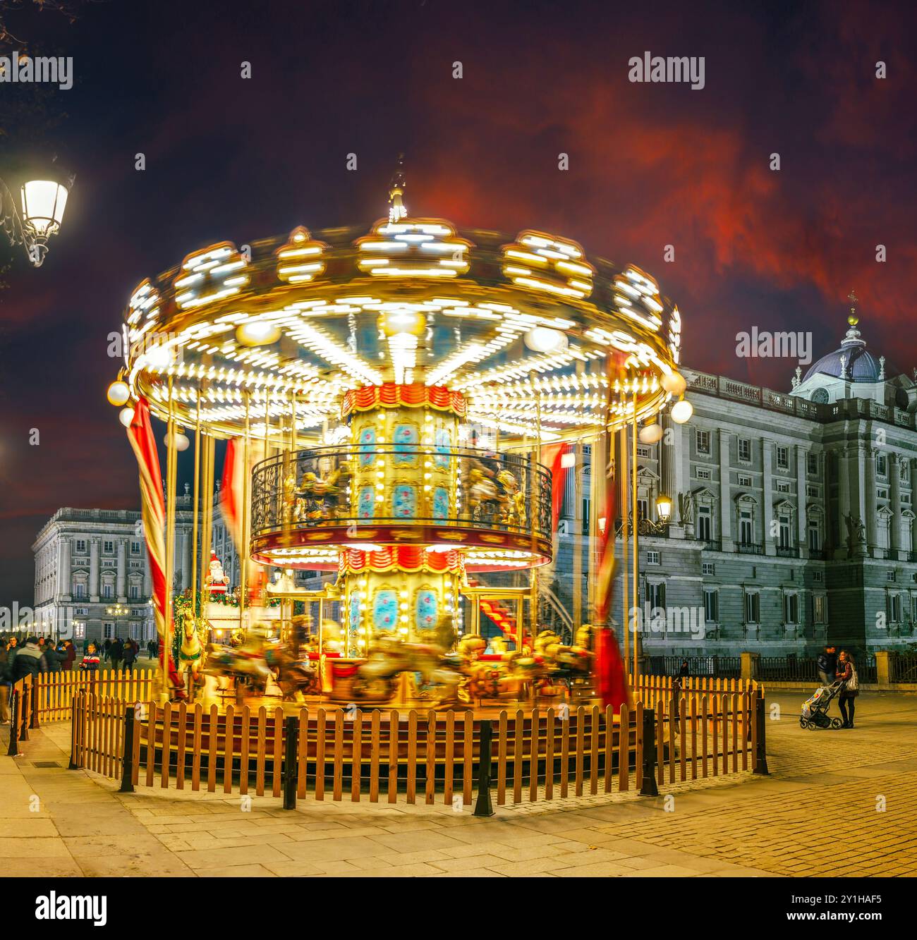 A brightly illuminated Carousel spins in front of the Royal Palace in ...
