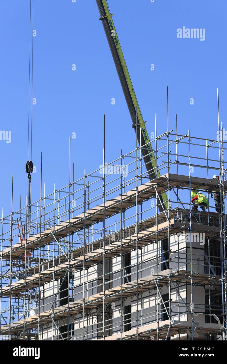 Building development with scaffolding and crane boom in the background ...
