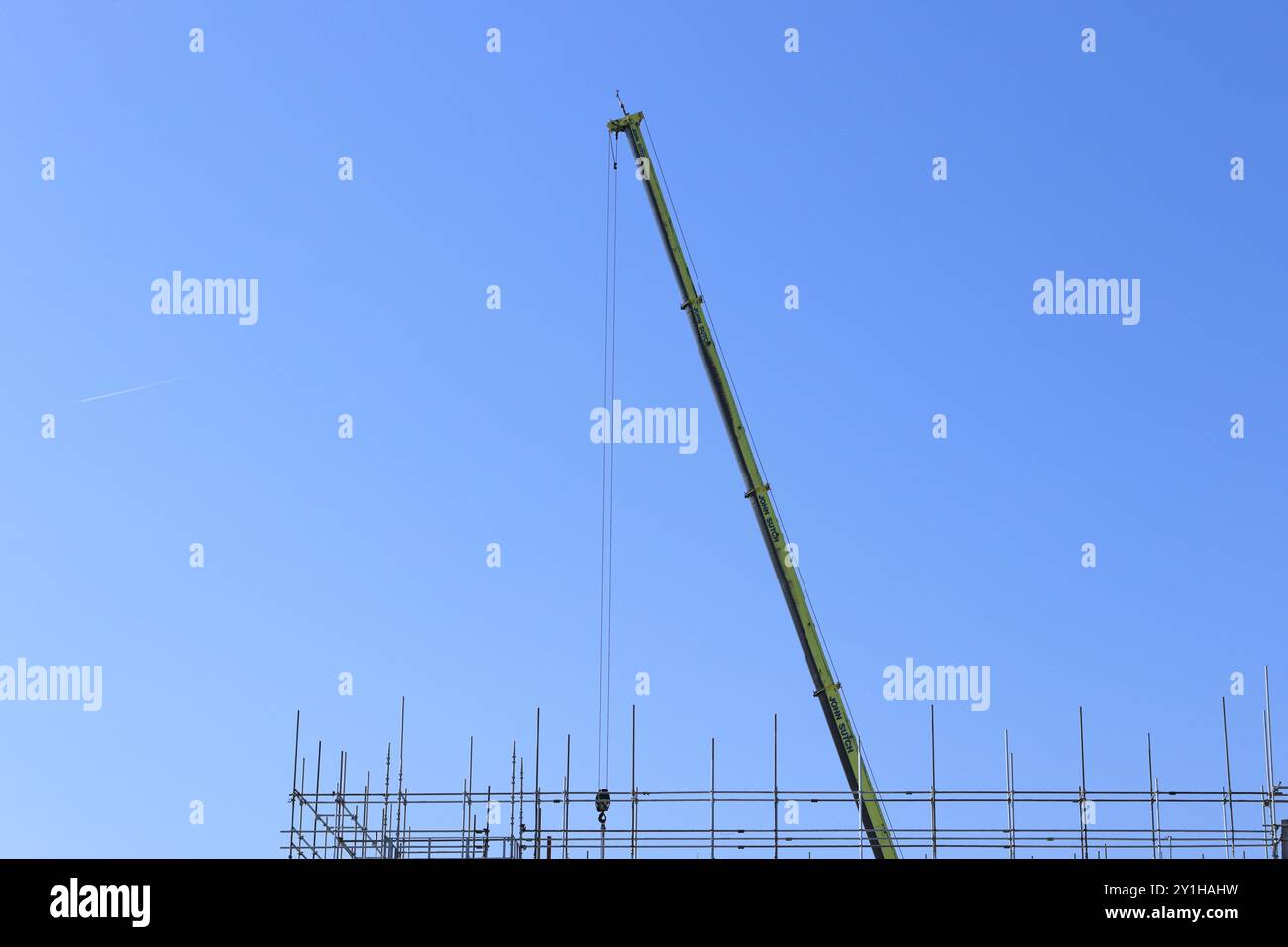 Crane boom above scaffolding with clear blue sky in radcliffe greater ...