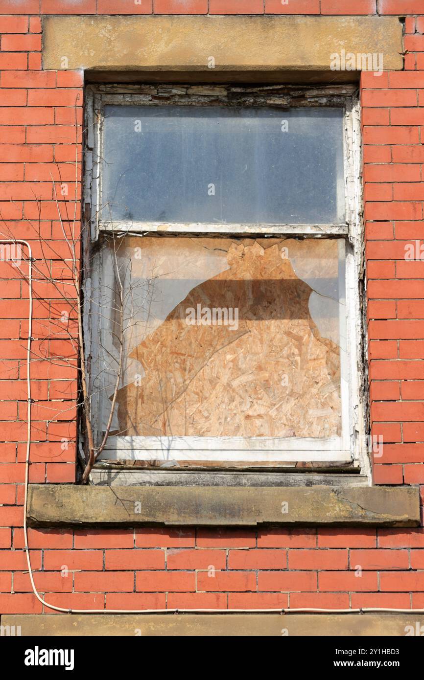 Boarded up broken window with white painted rotten wooden window frame ...