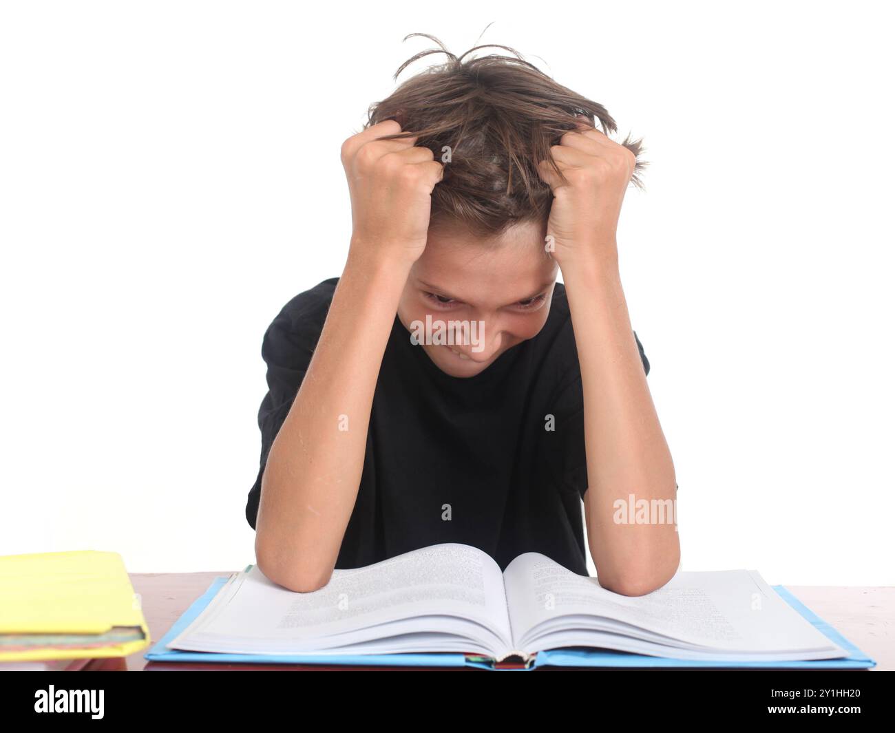 stressed out young boy studying with books on isolated white background ...