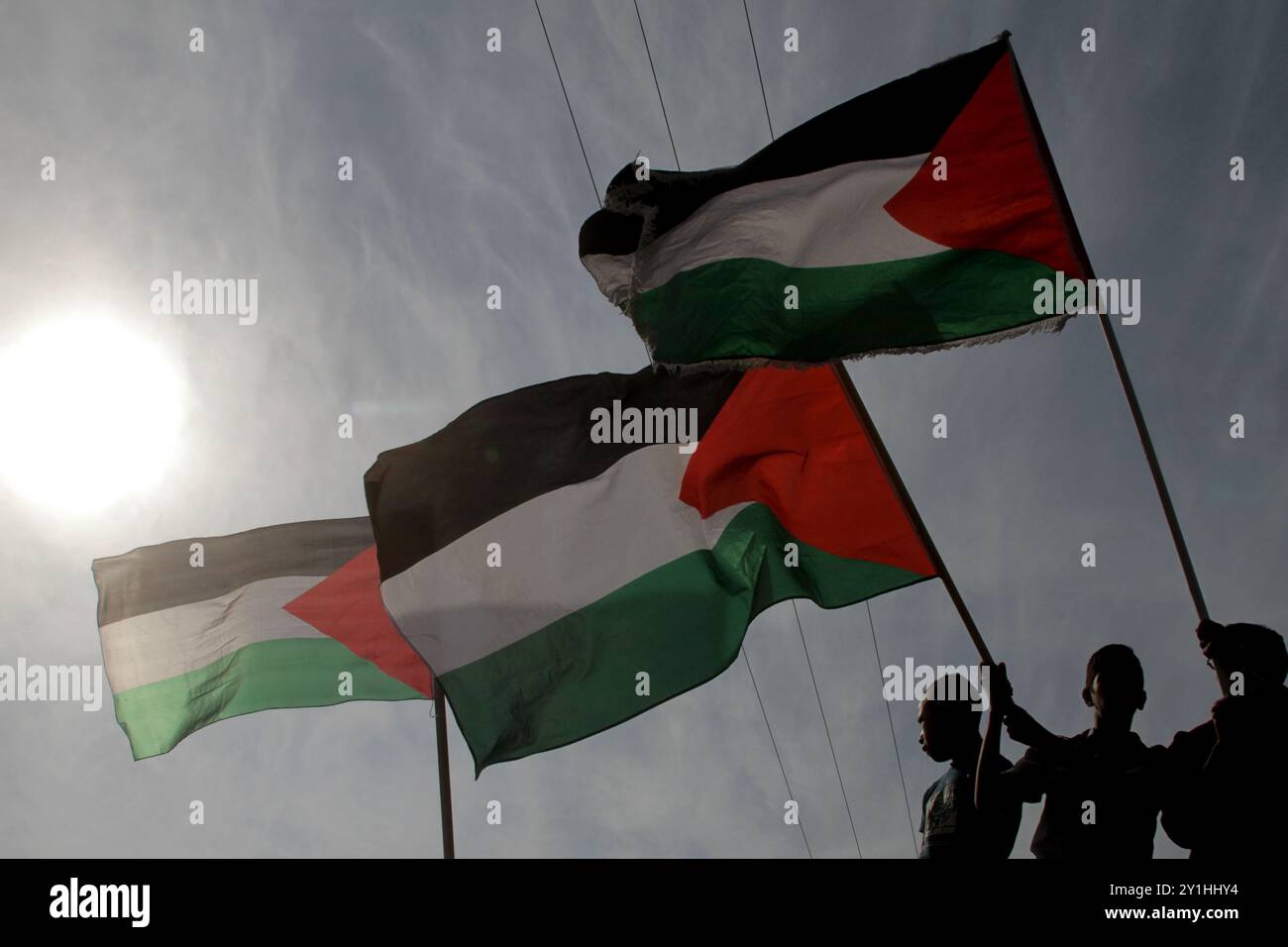 Palestinians watch the raising of a Palestinian flag during a rally ...