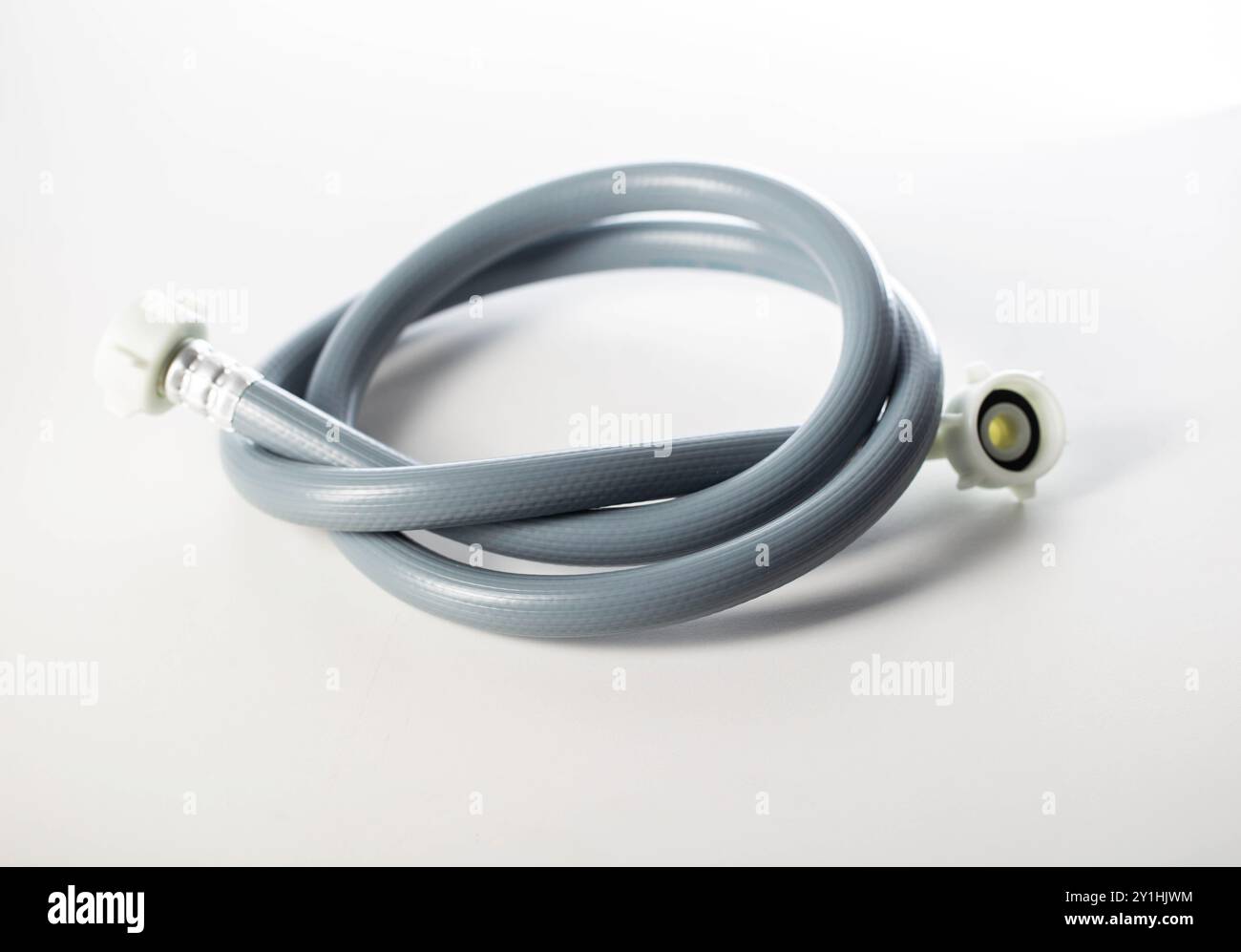 Gray twisted water hose from a washing machine on a white background ...