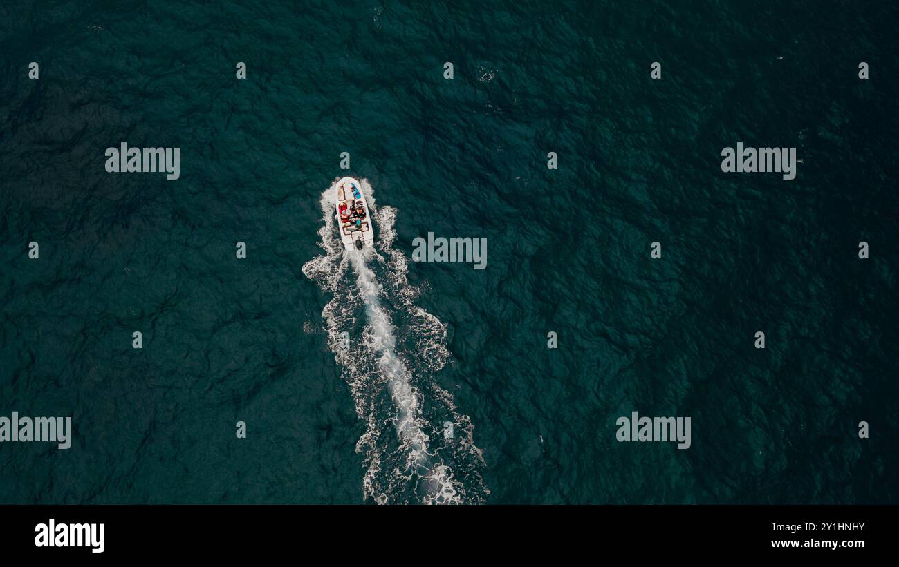 Aerial view of a speedboat cruising through the open ocean, leaving a ...
