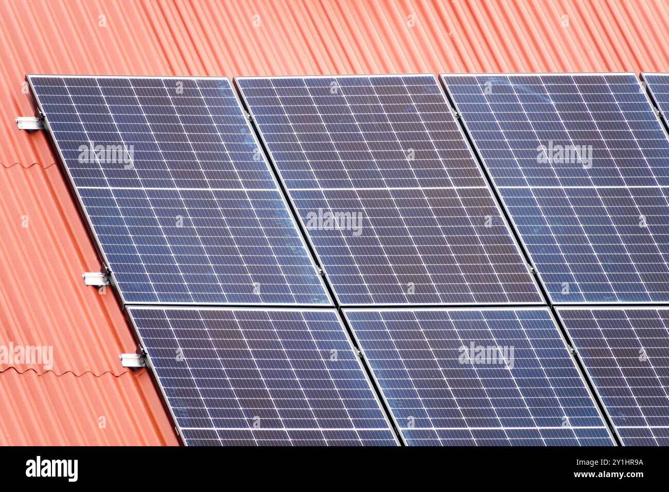 Close-up of solar panels installed on a red corrugated roof for ...