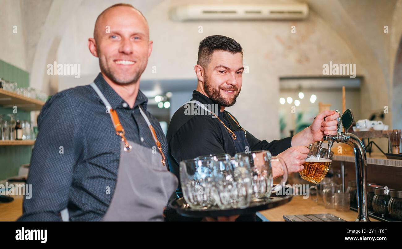 Stylish bearded barman dressed black uniform beer tapping at bar ...