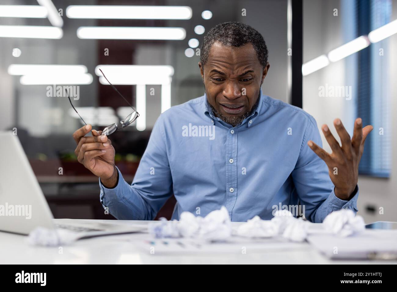 Businessman experiencing frustration in modern office environment ...