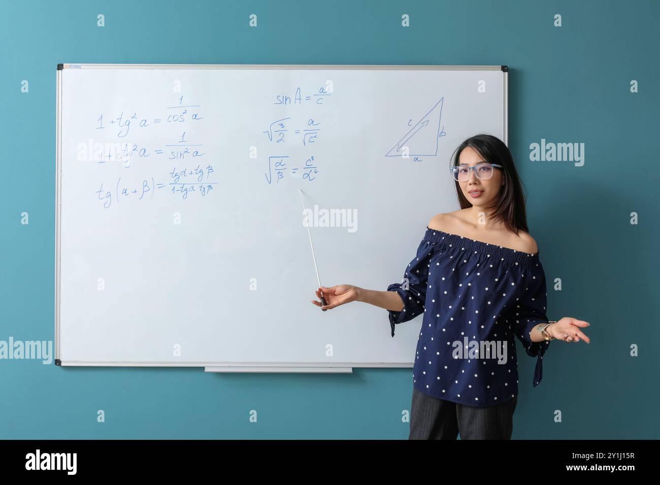Asian Math teacher near flipboard in classroom Stock Photo - Alamy