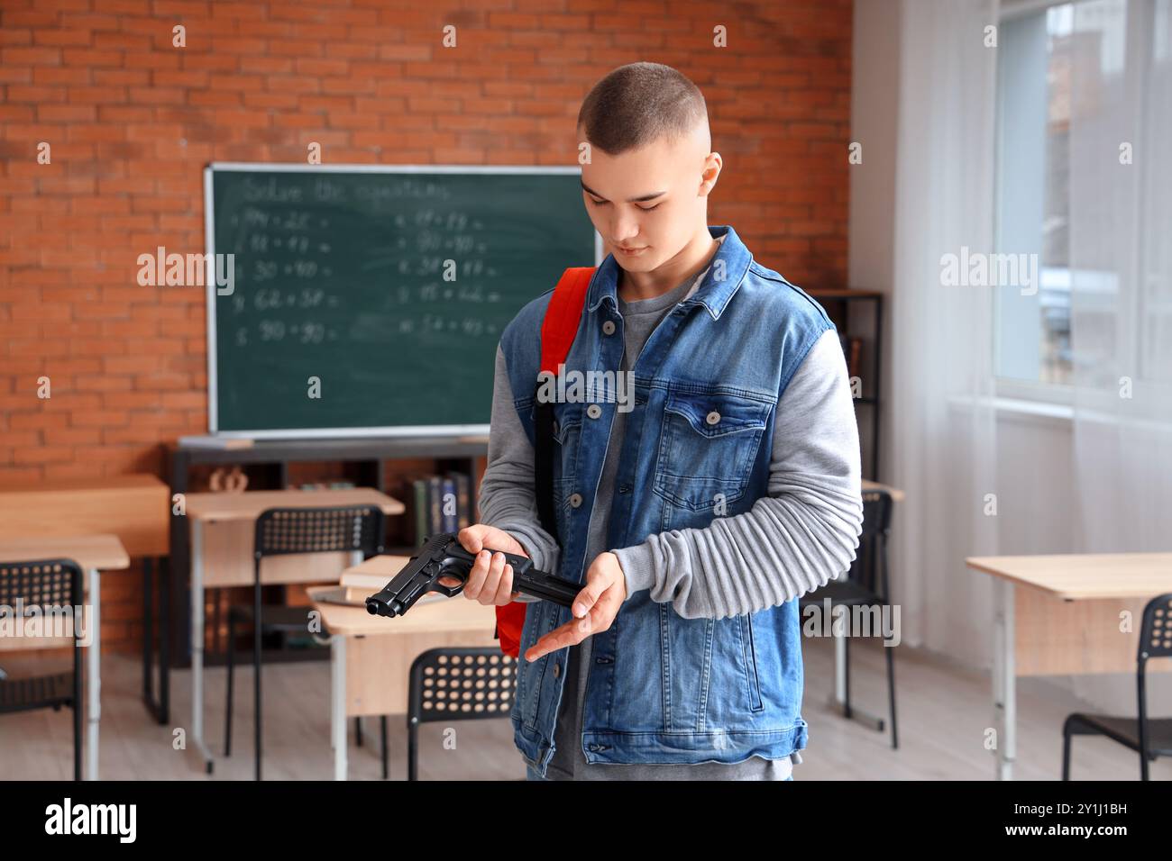 Male student with gun in classroom Stock Photo - Alamy