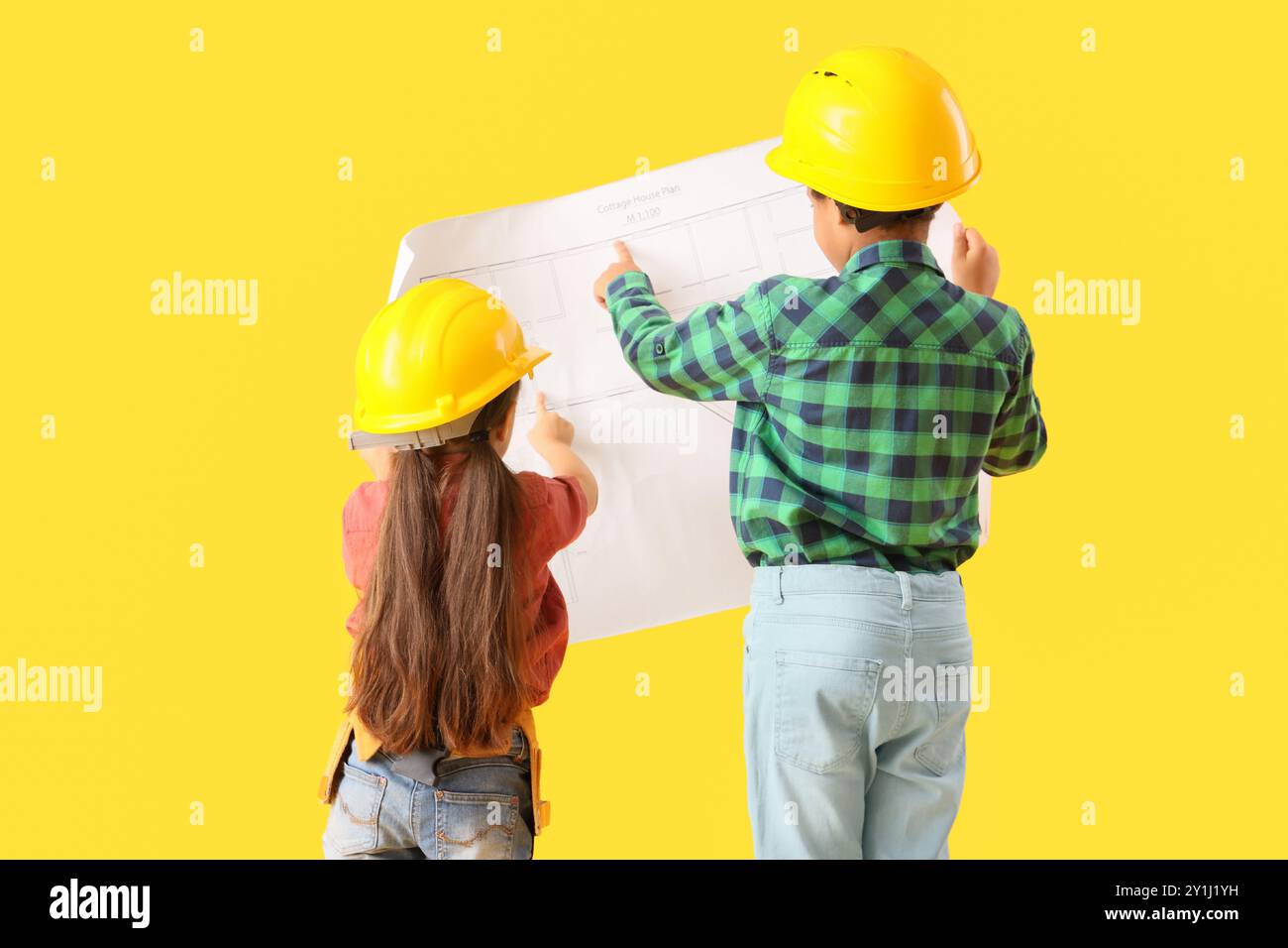 Cute little architects reading blueprint on yellow background, back ...
