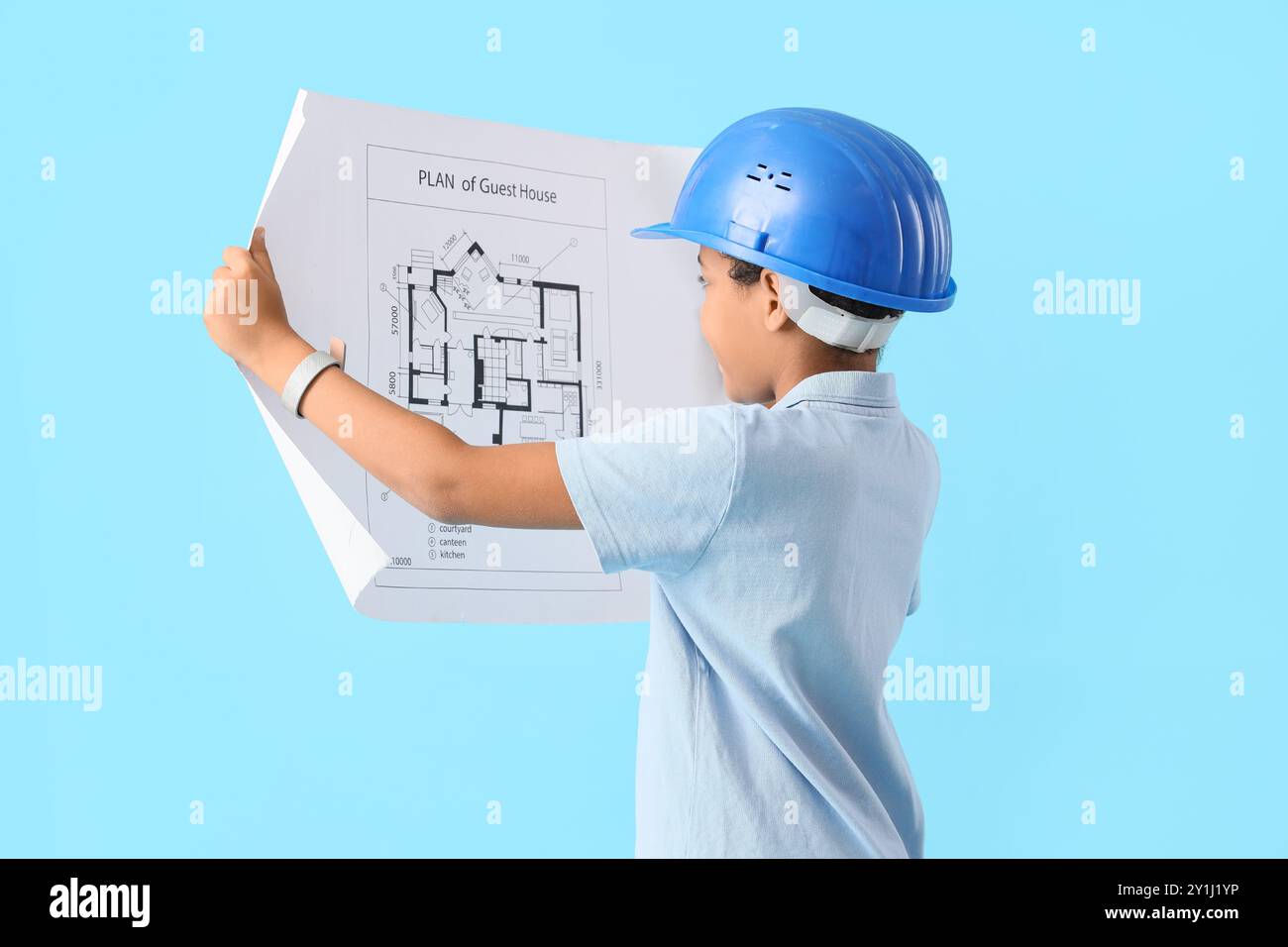 Cute little architect with blueprint on blue background Stock Photo - Alamy