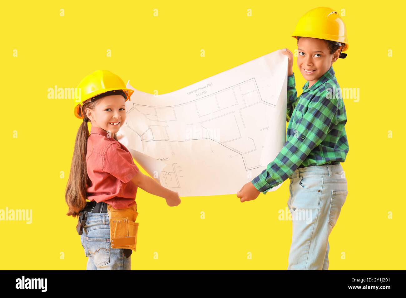 Cute little architects with blueprint on yellow background Stock Photo ...