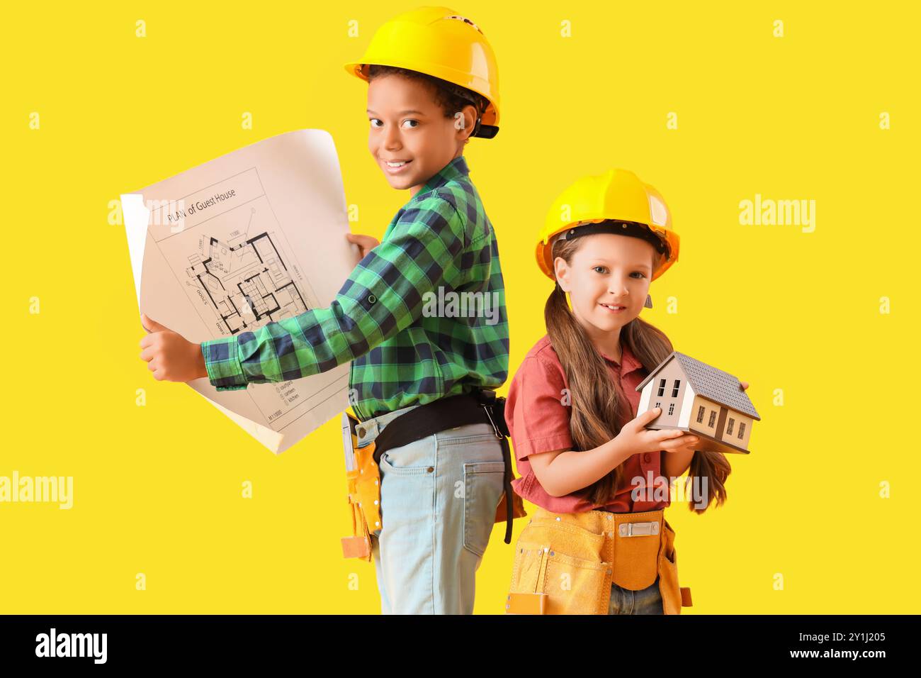 Cute little architects with house model and blueprint on yellow ...