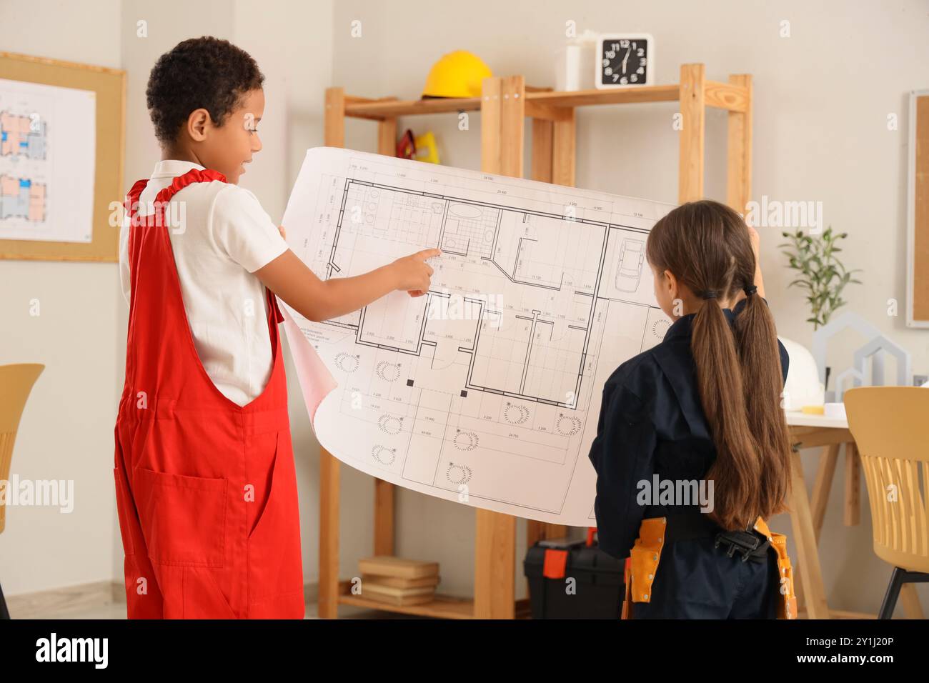 Cute little architects reading blueprint at home Stock Photo - Alamy