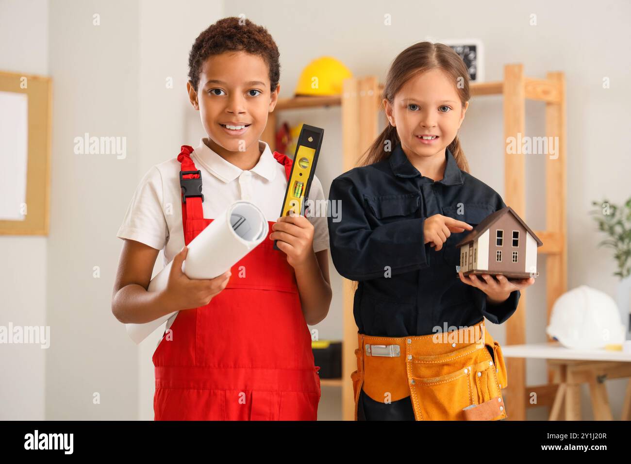 Cute little architects with house model and blueprint at home Stock ...