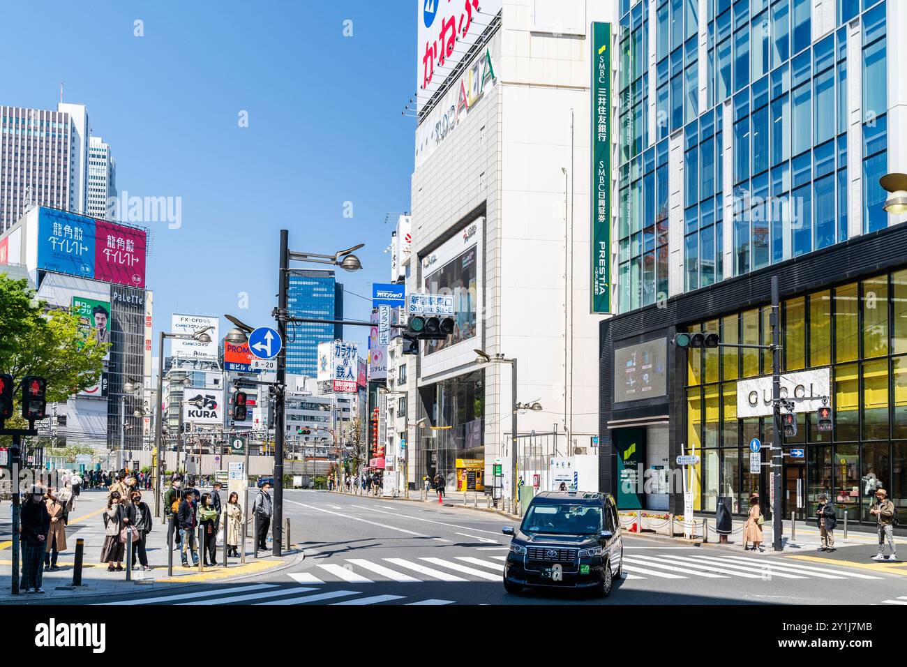 View along Shinjuku dori, road, on a hot springtime day. Taxi crossing ...