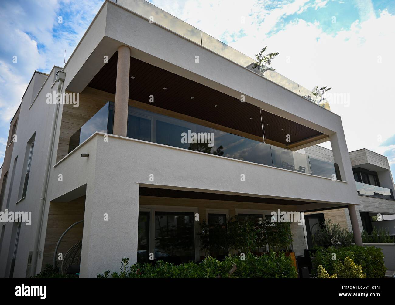 Modern building showcasing its sleek design with balconies enclosed by ...