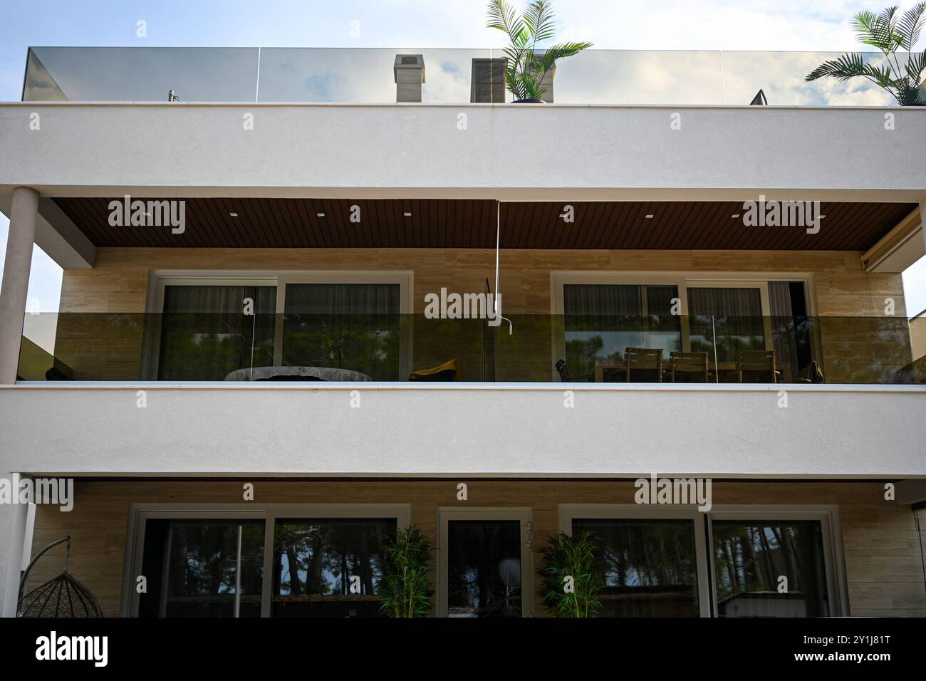 Modern building showcasing its sleek design with balconies enclosed by ...