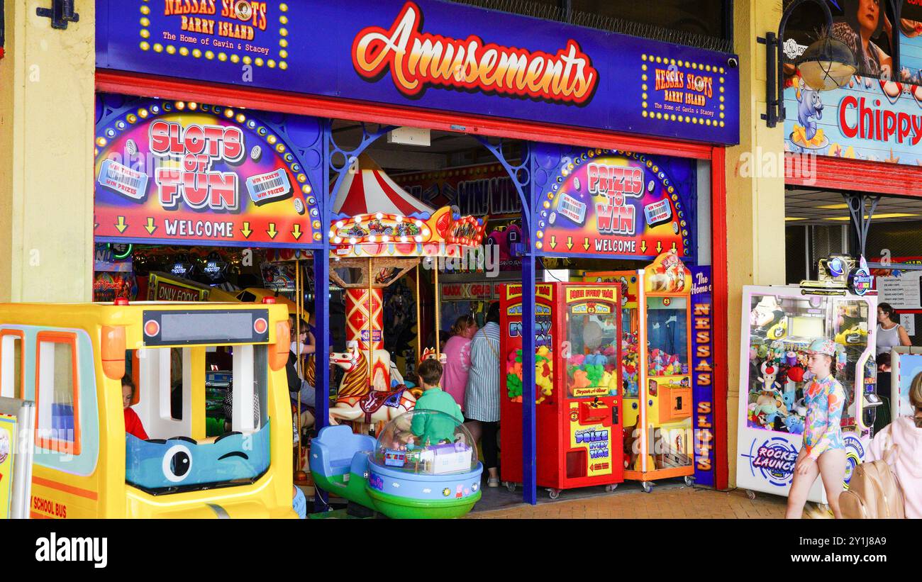 Barry Island, Wales, Aug 30 2024: People walk in the shelters at Barry Island visiting amusement ...