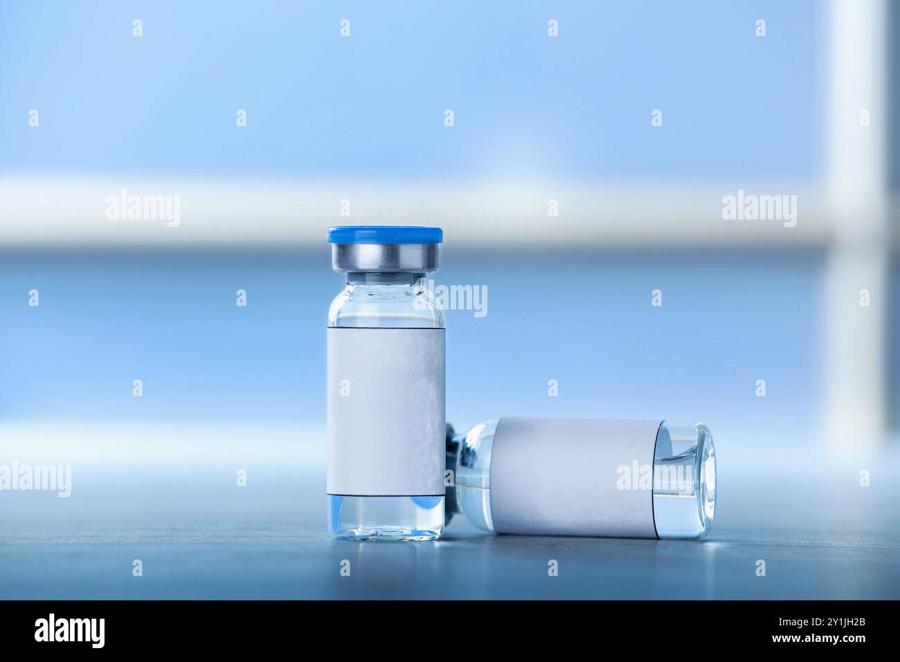Medication in glass vials with blank labels on table, space for text ...
