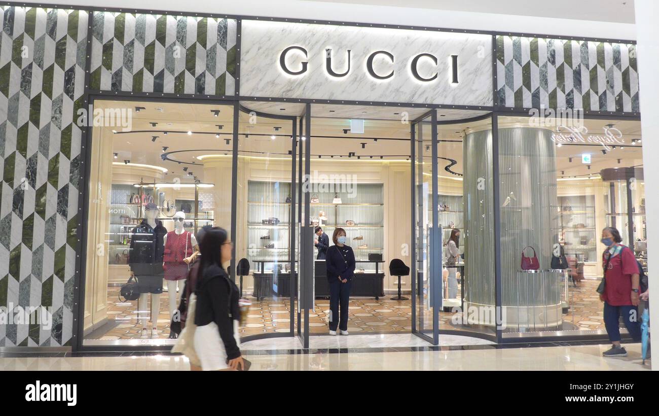 Pedestrian walks past the Italian luxury fashion house Gucci logo and ...