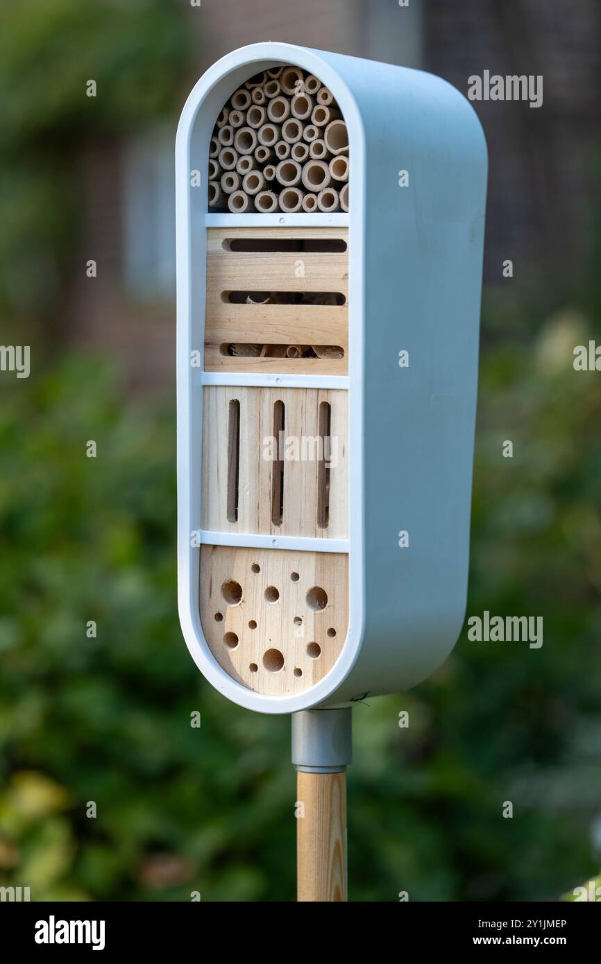 Modern insect hotel on a pole in a garden with shelter for bees ...
