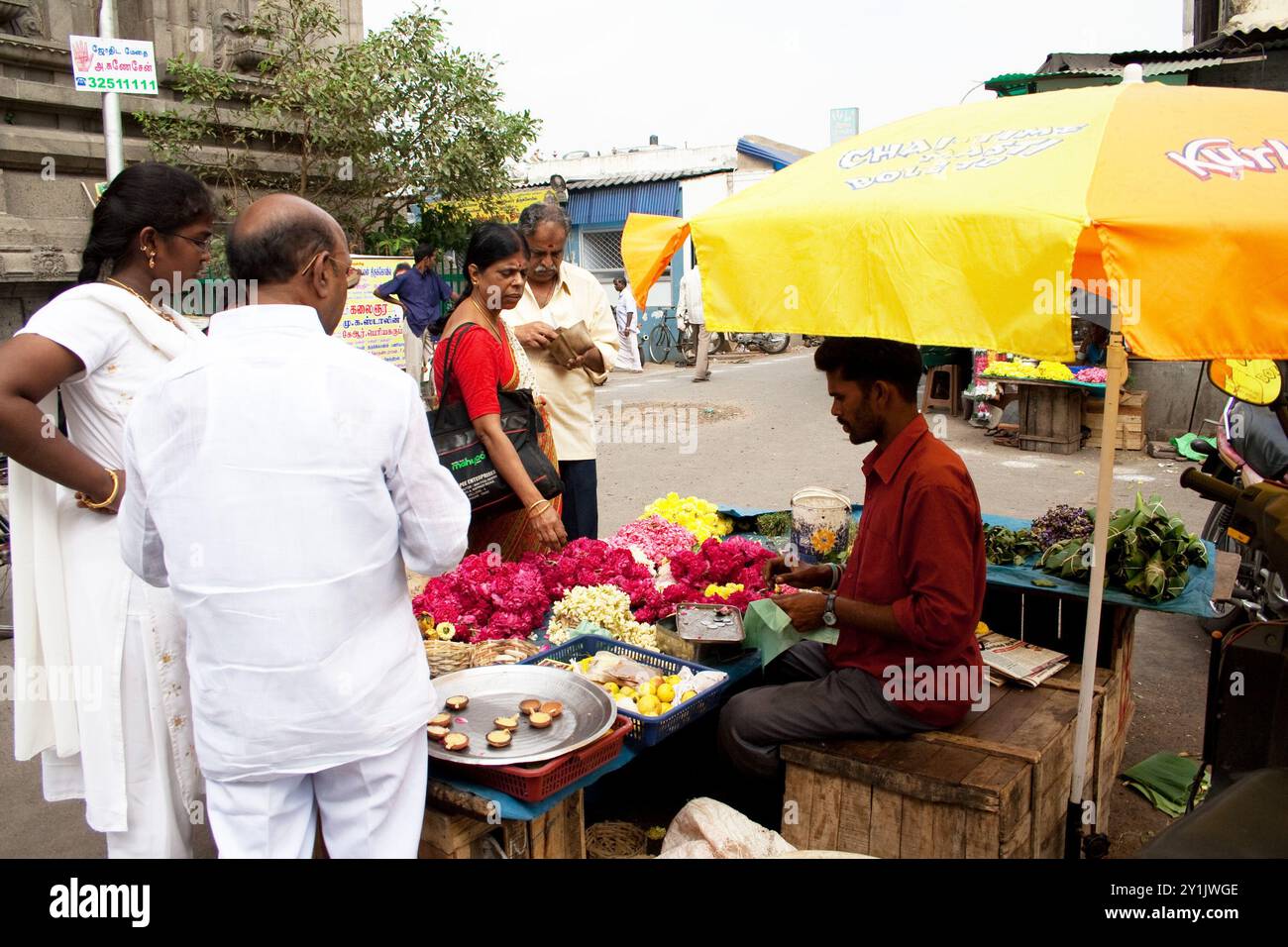 Young man selling garlands and lights outside a Hindu Temple, Chennai ...