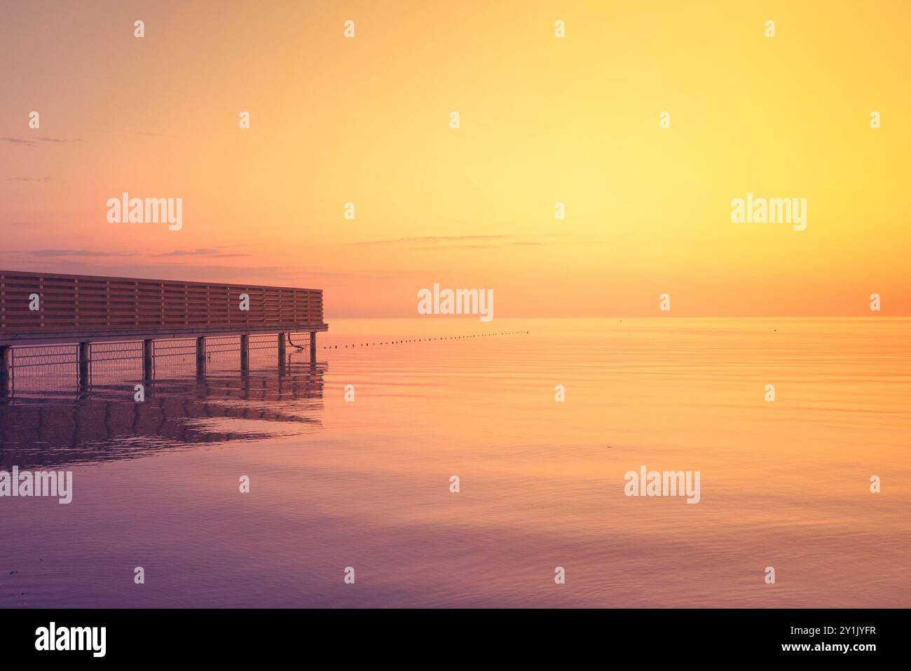 Pier in the sea mist at sunrise Stock Photo - Alamy