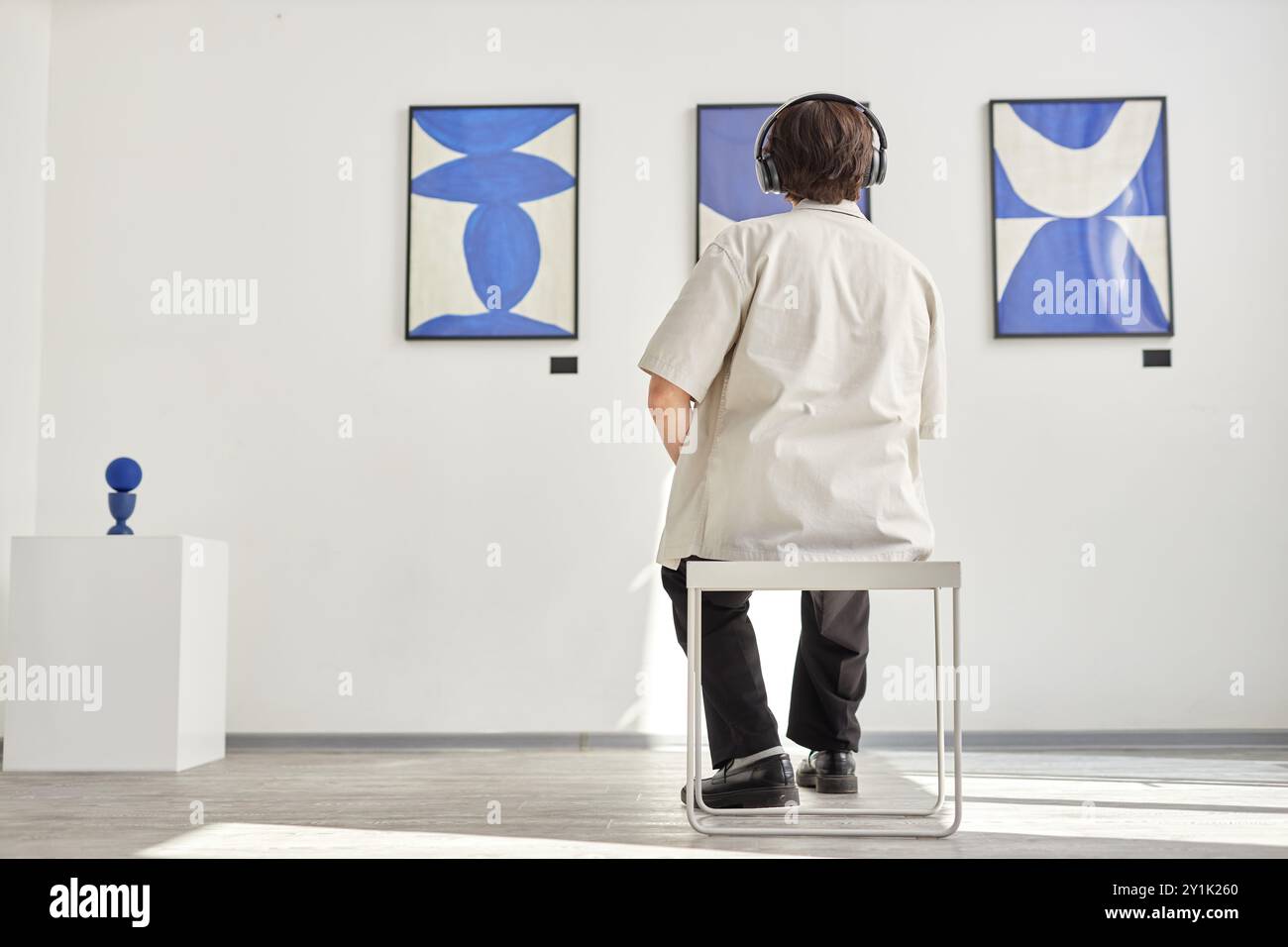 Full length back view of unrecognizable young man looking at abstract ...