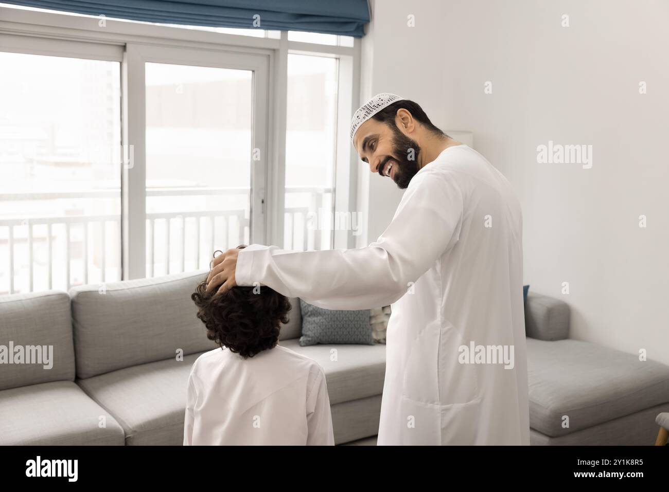 Positive Middle Eastern father cuddling little sons head Stock Photo ...