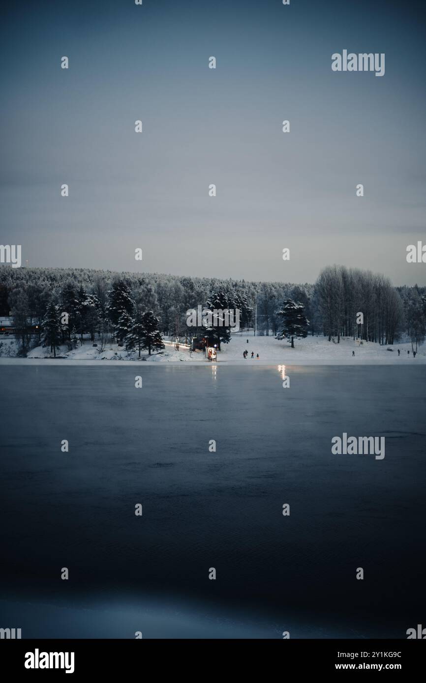 Sauna lights across Ounasjoki river in polar night in Rovaniemi ...