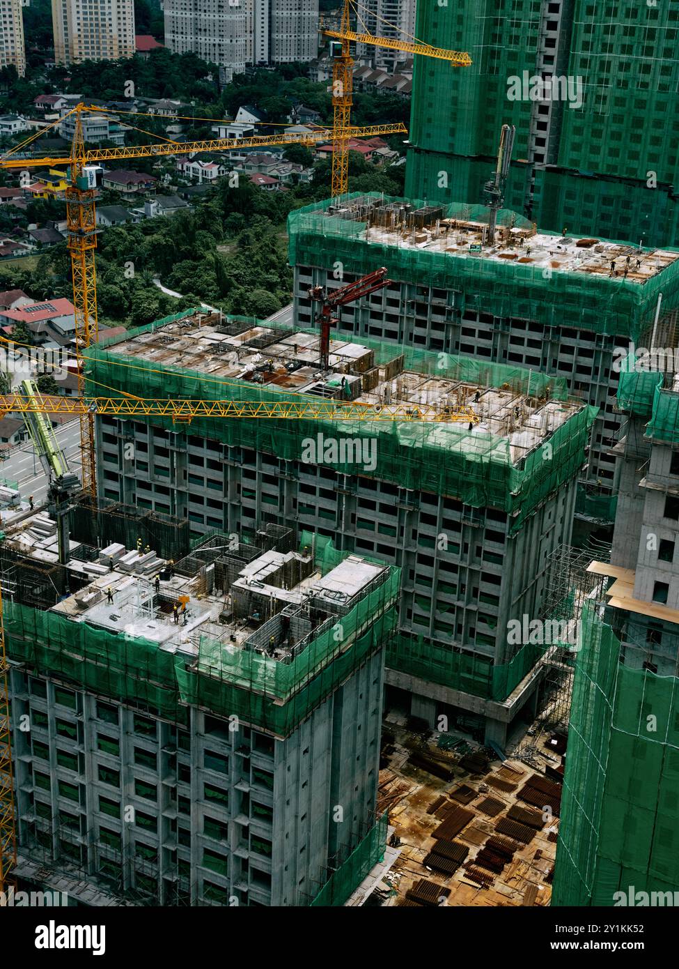 Construction site with green safety netting and cranes in an urban ...