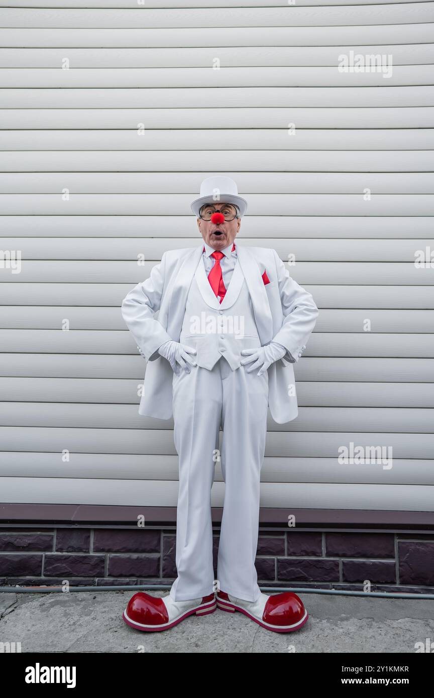 Full-length portrait of a clown in a white classic suit and a vintage ...