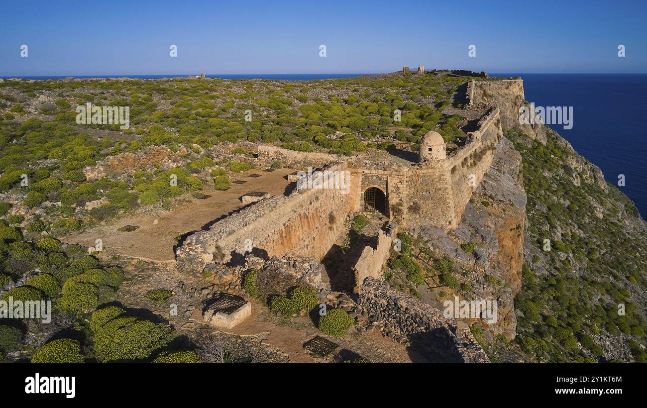 Drone shot, An ancient fortress ruin running along an overgrown cliff ...
