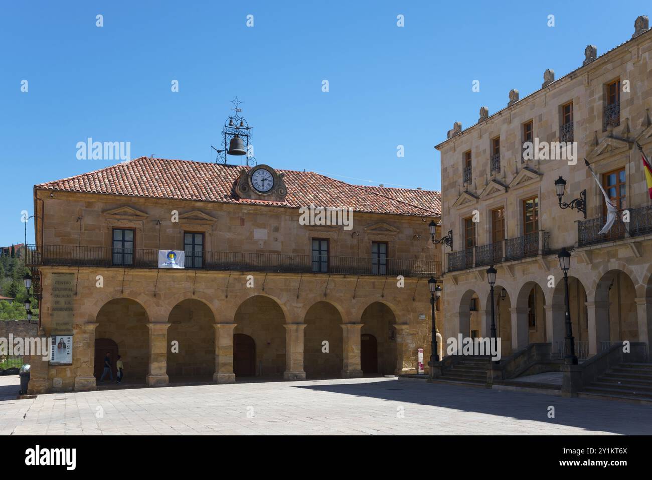 A quiet square with historic buildings, including a clock tower and ...
