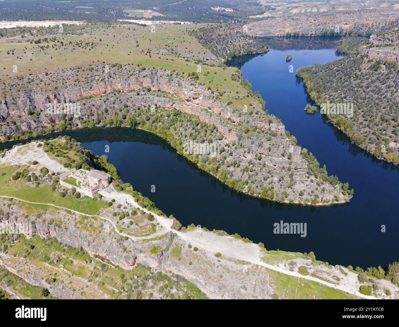Meandering river amidst deep gorges and lush vegetation, bird's eye ...