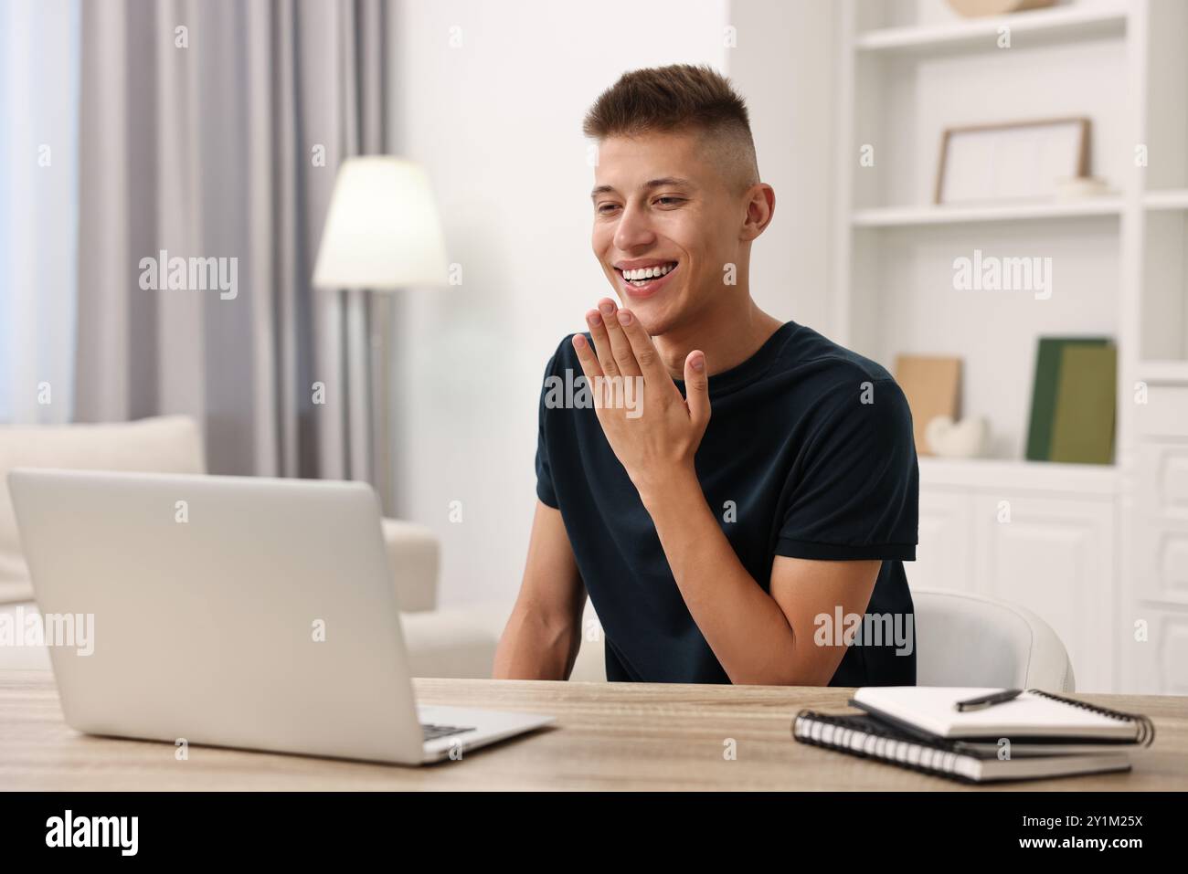 Young man using sign language during video call indoors Stock Photo - Alamy