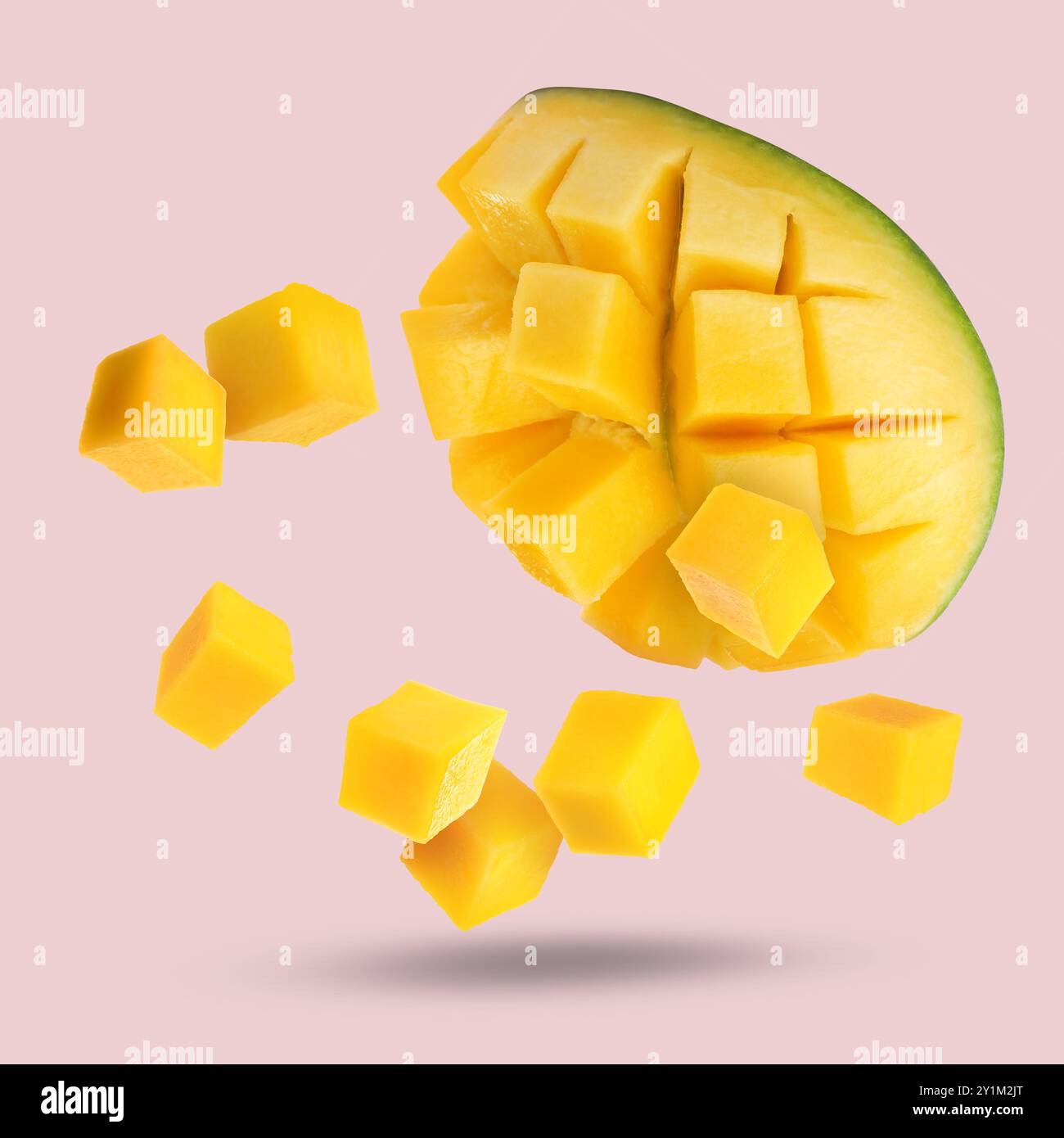Sweet fresh mango cut in cubes falling on pink background Stock Photo ...
