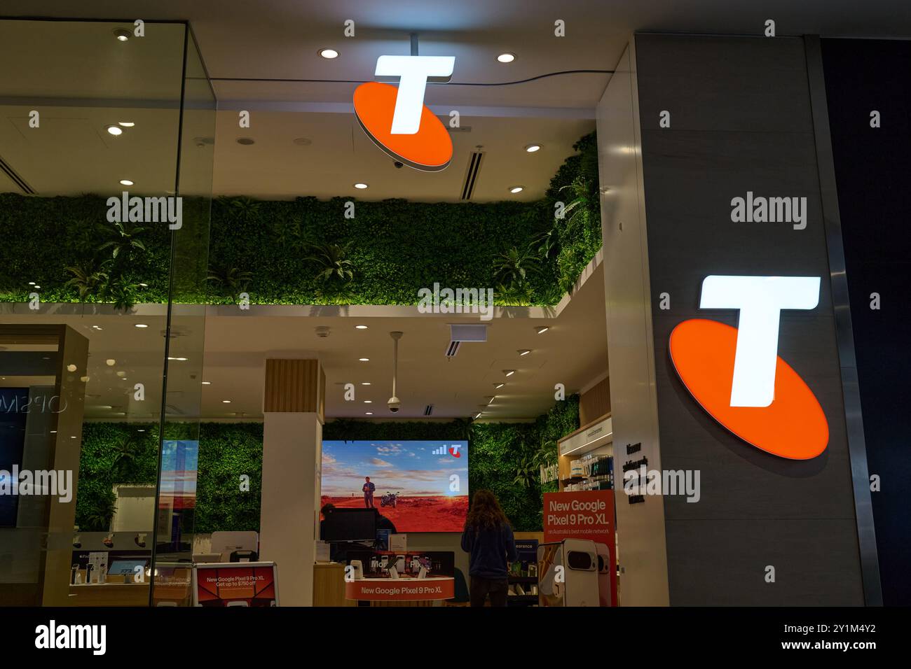 Illuminated Telstra logos above and beside a Telstra Shop entrance ...