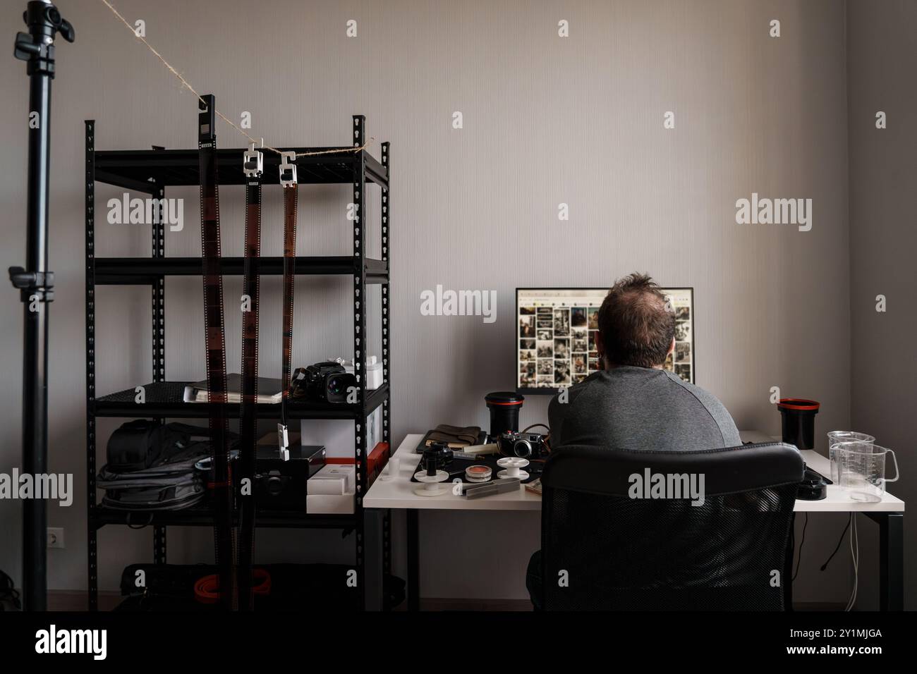 Photographer working on image editing in a home studio Stock Photo - Alamy