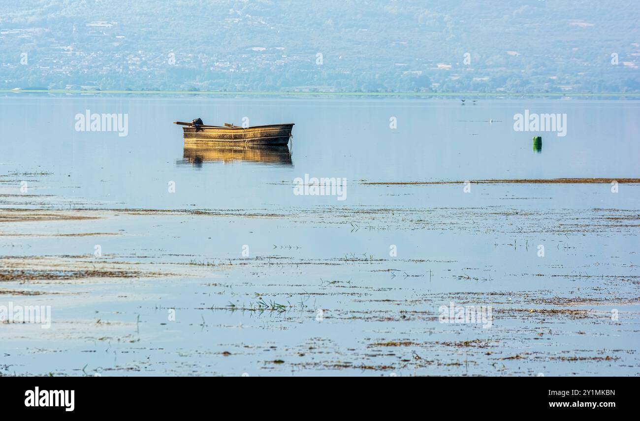 A solitary boat floats peacefully on the calm waters of Lake Kerkini ...