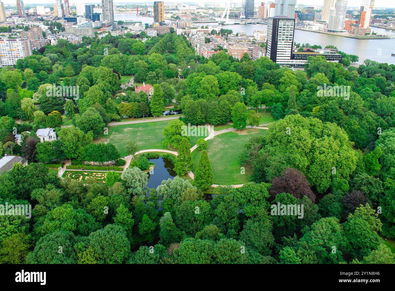 Aerial view of a lush green park with trees, pathways, and a pond ...