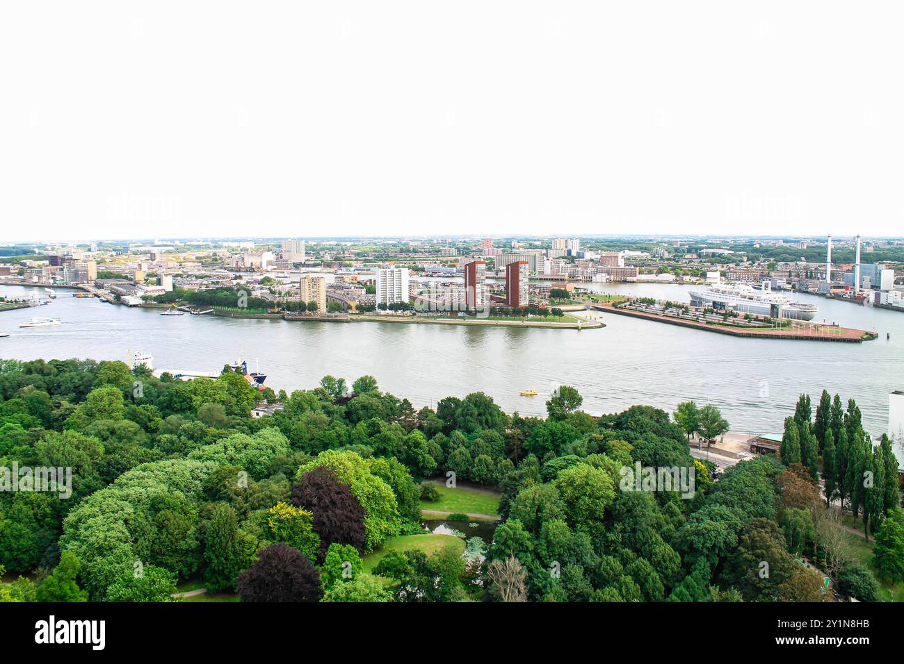 Aerial view of a river surrounded by lush greenery and urban buildings ...