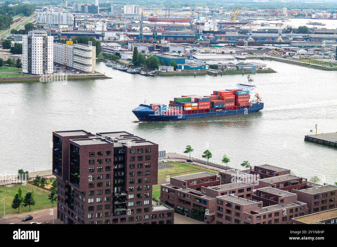 Aerial view of a busy port with a large container ship navigating the ...