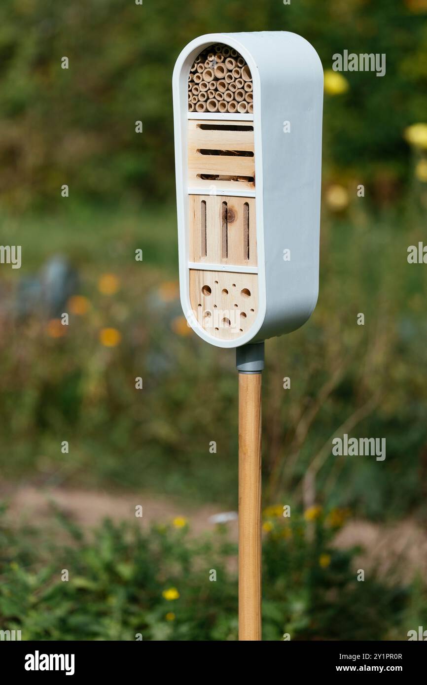 Modern insect hotel on a pole in a garden with shelter for bees ...